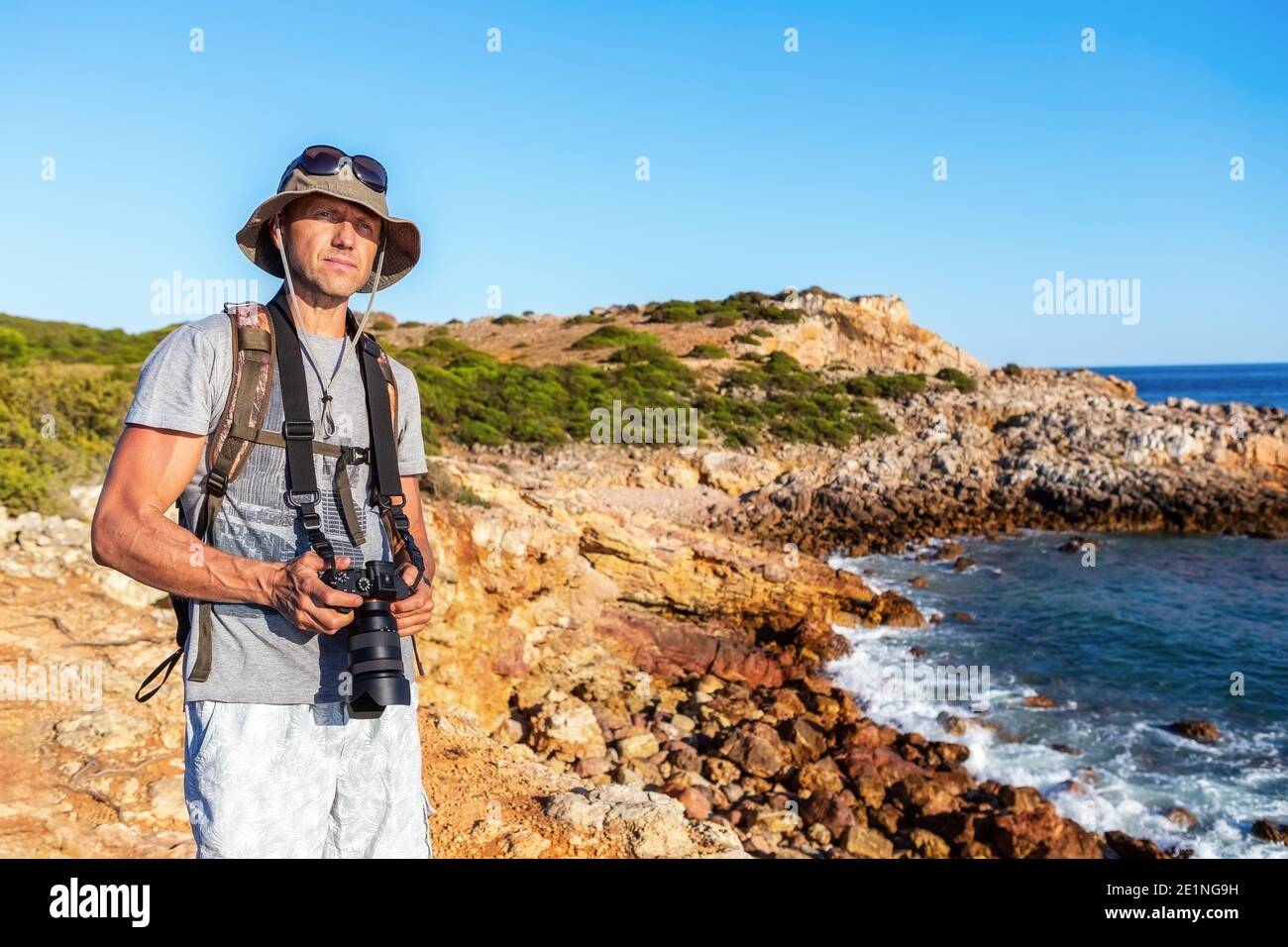 Male photographer traveler with a camera on the seashore, portrait ...