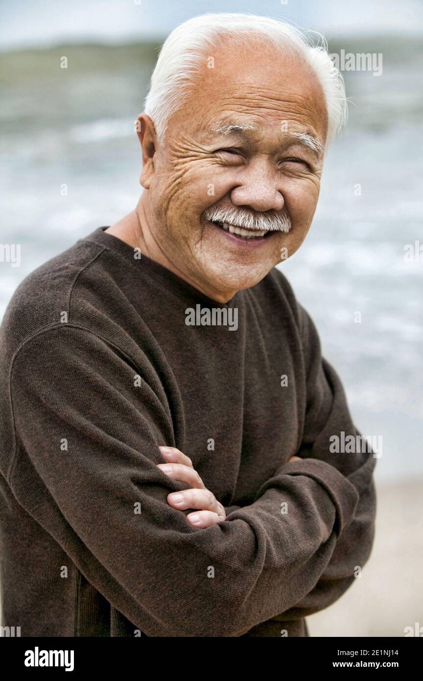 Portrait of senior chinese man standing on the beach Stock Photo - Alamy