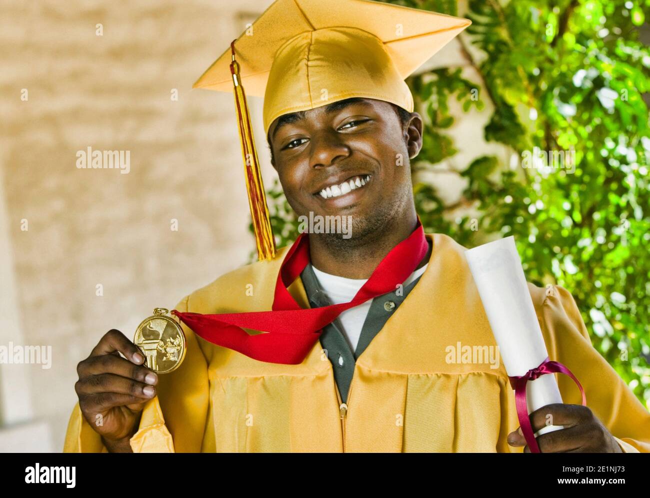Photo of confident male student with diploma and medal on graduation ...