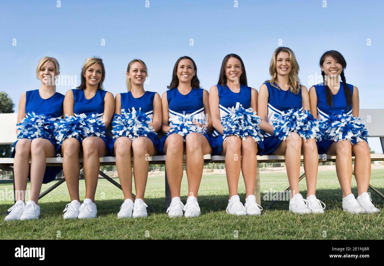Photo of young attractive Cheerleading Squad Sitting on Bench Stock ...