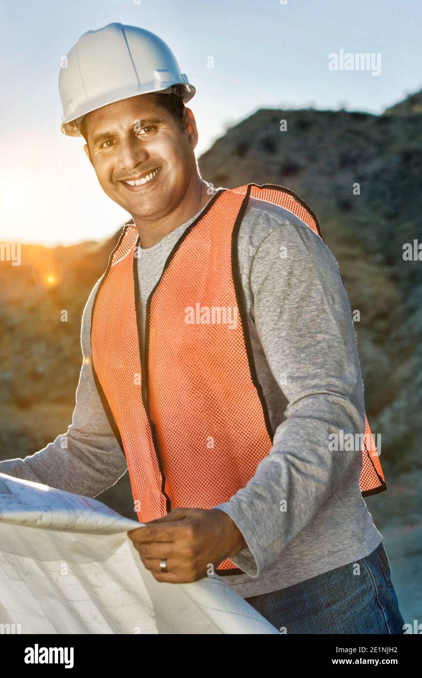 Photo of mid adult engineer holding blueprint Stock Photo - Alamy