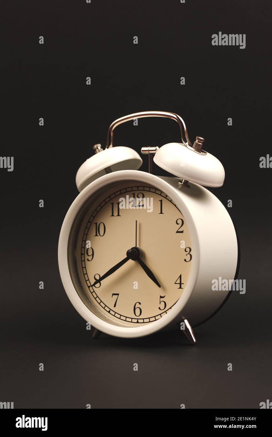 Old-style vintage retro alarm clock on dark black isolated background ...