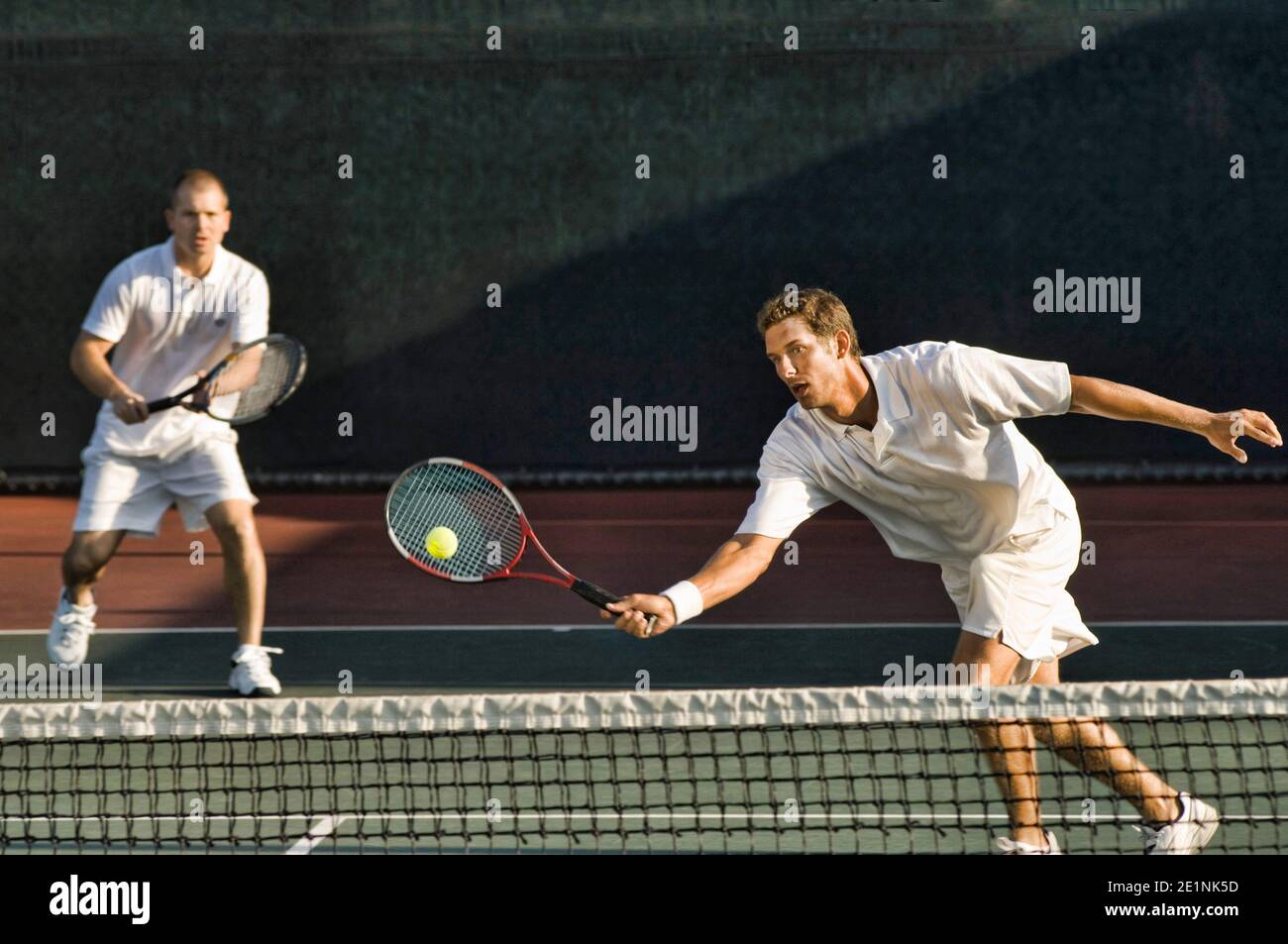 Portrait of man hitting tennis ball in court match Stock Photo - Alamy