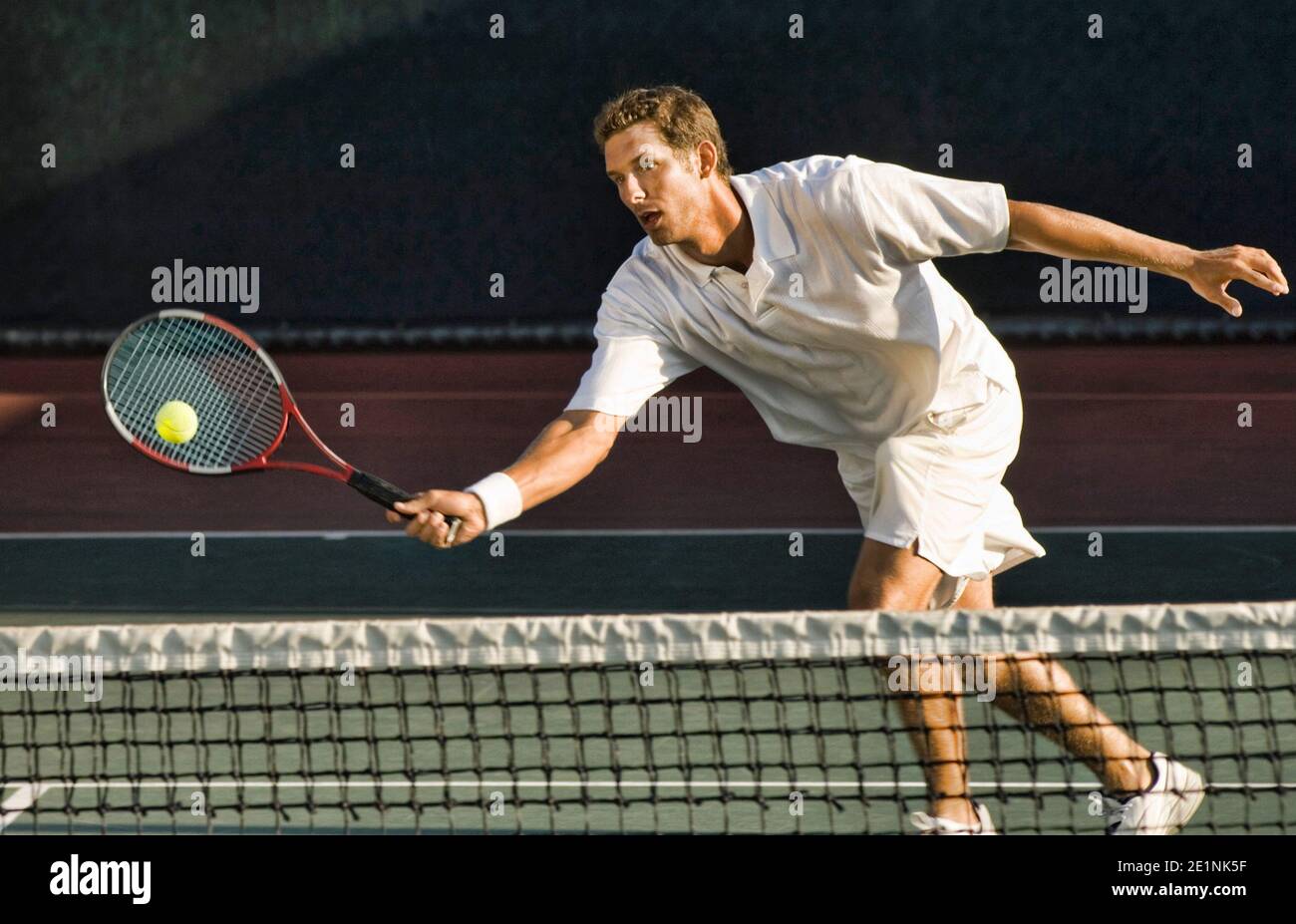 Portrait of man hitting tennis ball in court match Stock Photo - Alamy