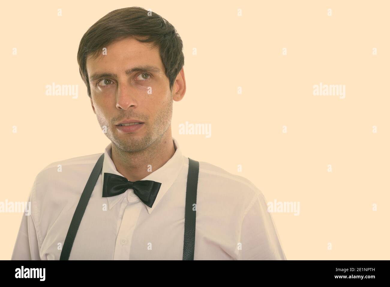 Studio shot of young handsome man thinking and looking up while wearing ...