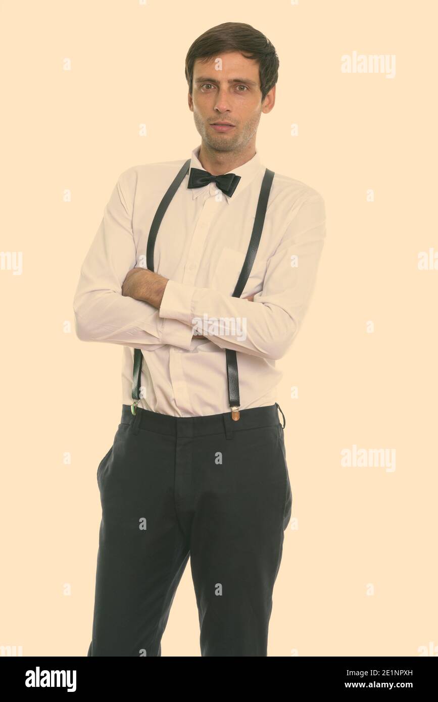 Studio shot of young handsome man standing while wearing suspenders and ...