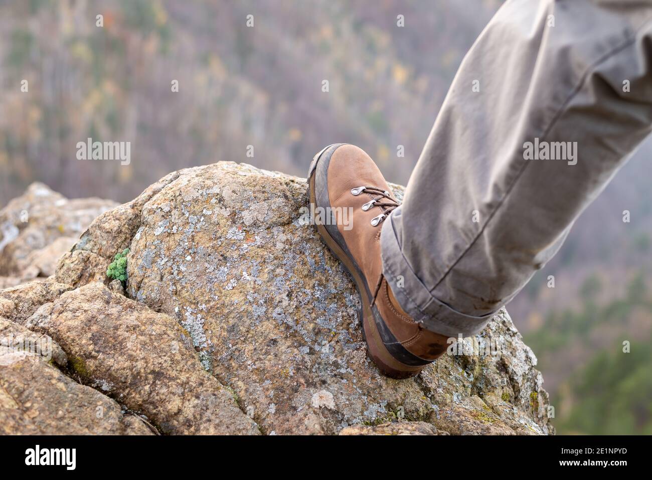 Leg of a man in boot on a rock with a view to hills during hiking Stock ...