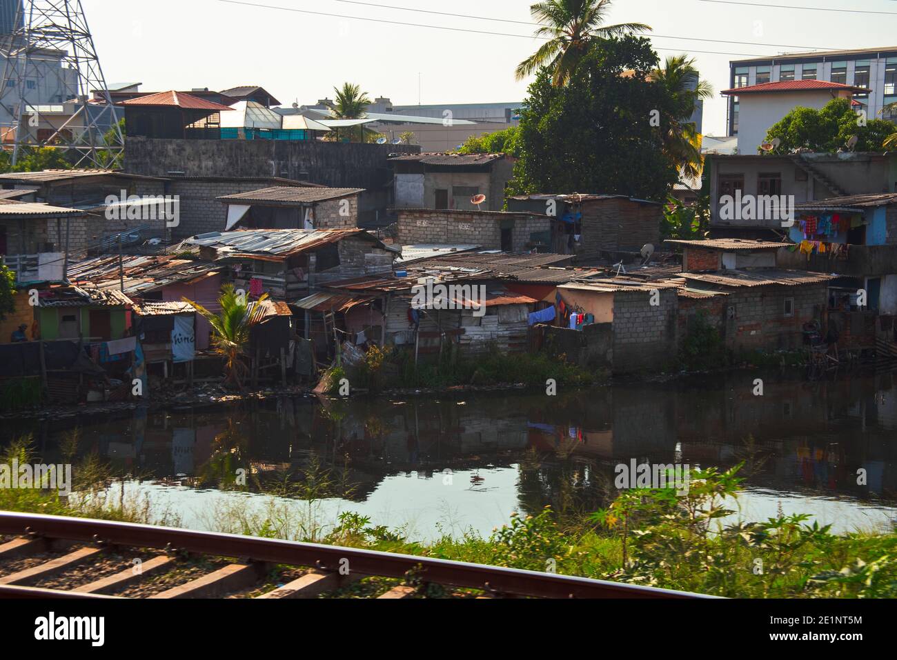 Slums next to train tracks at the poluted river of Kelani in Colombo ...