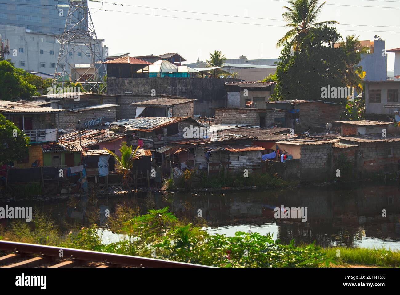 Slums next to train tracks at the poluted river of Kelani in Colombo ...