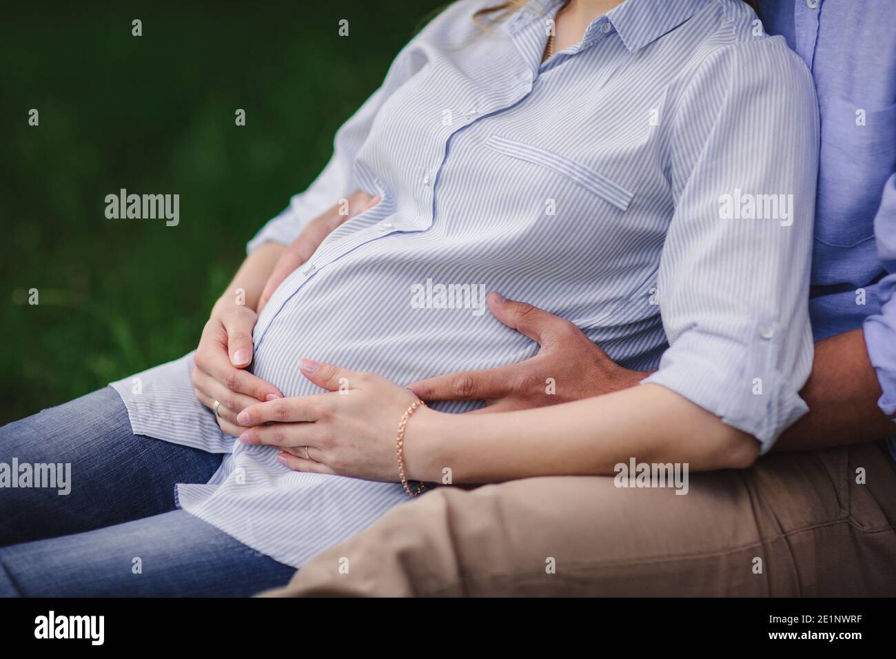 Young couple expecting baby hugging stomach Stock Photo - Alamy