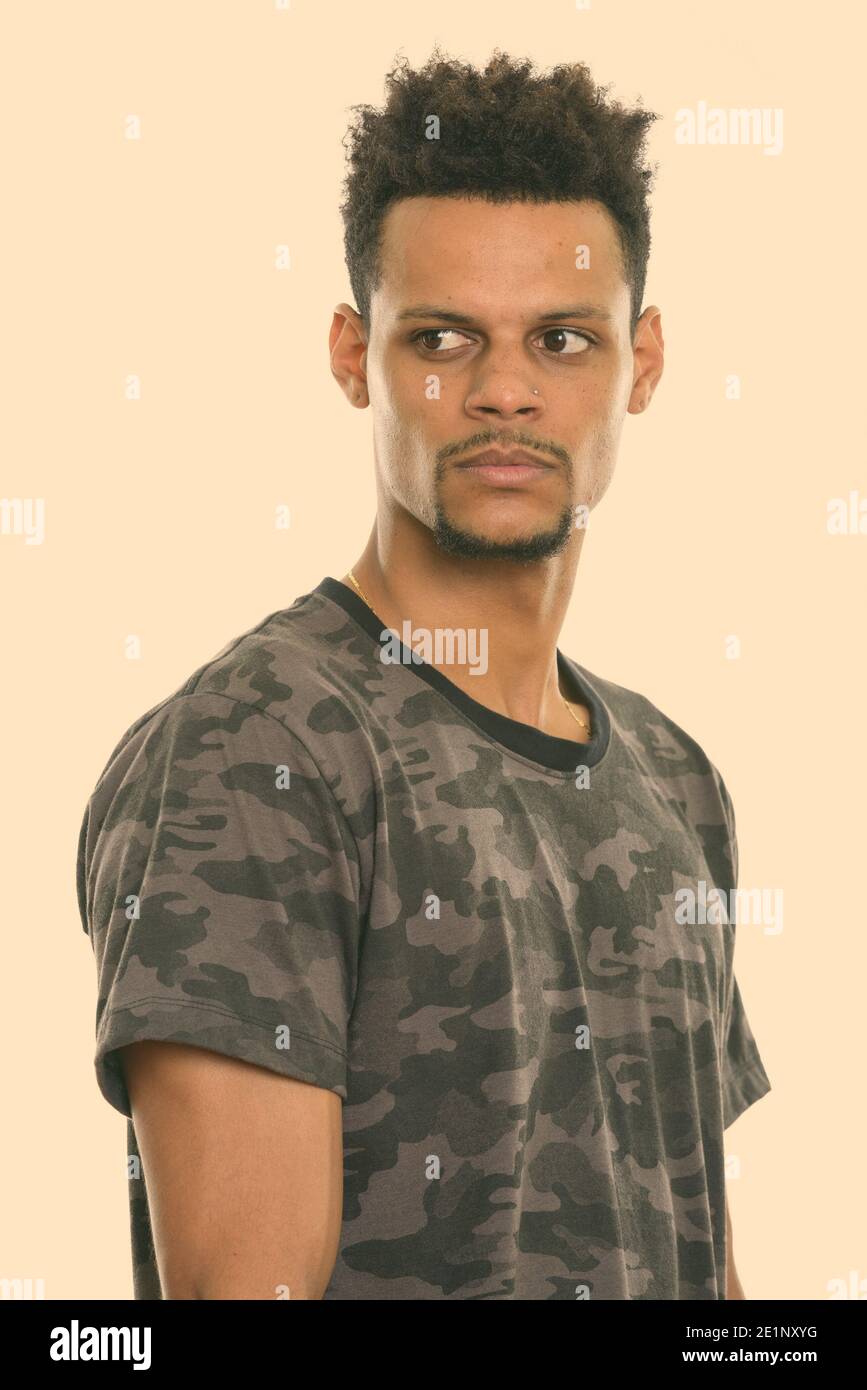 Studio shot of young African man thinking while looking back Stock ...