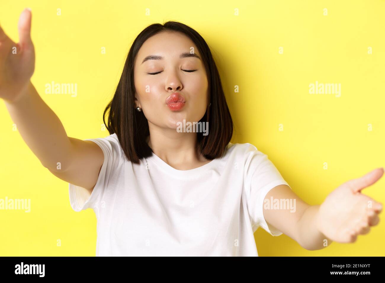 Close up of cute asian woman stretch out hands to hold smartphone ...
