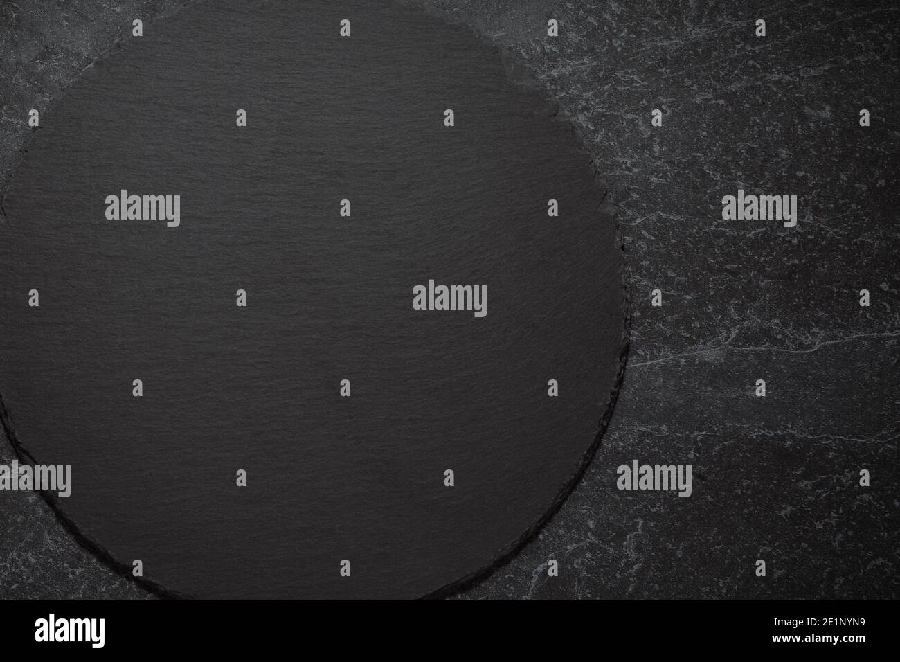 Slate plate on table. black slate stone on marble background. copy ...