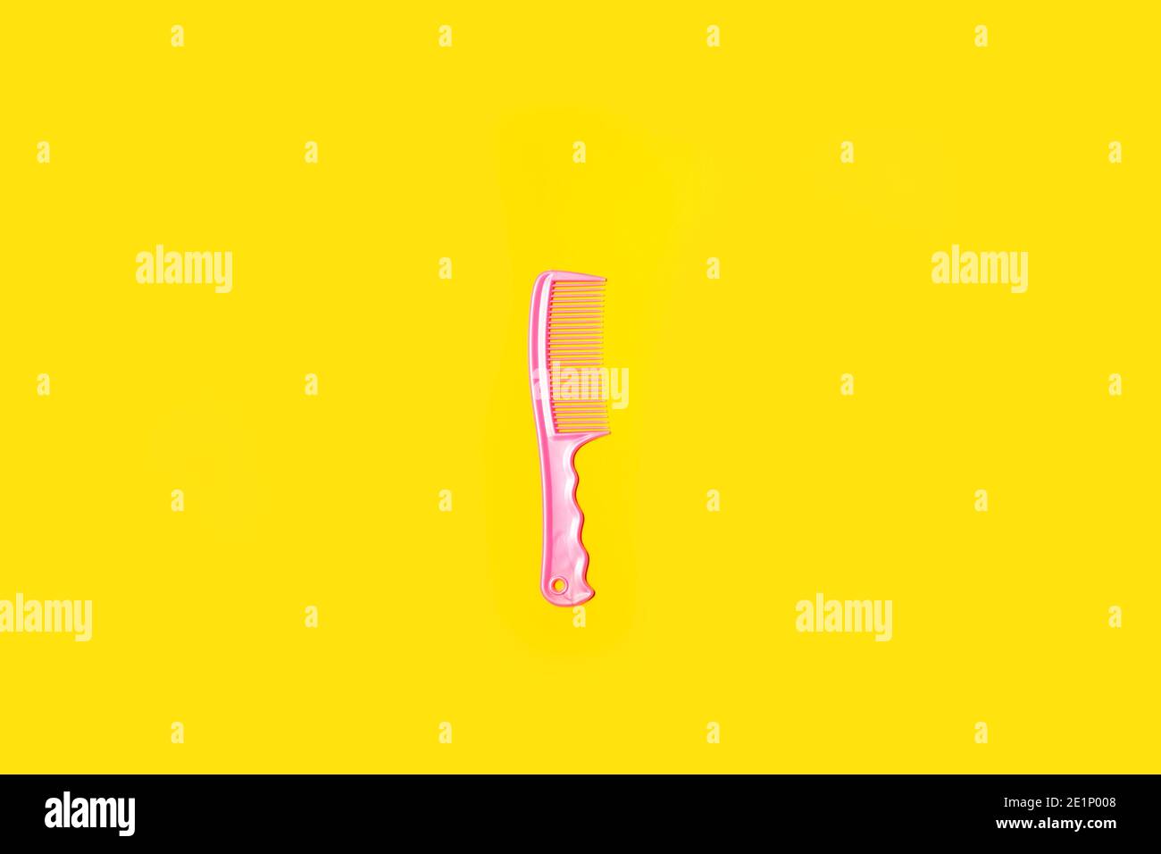 pink comb on yellow background Stock Photo - Alamy