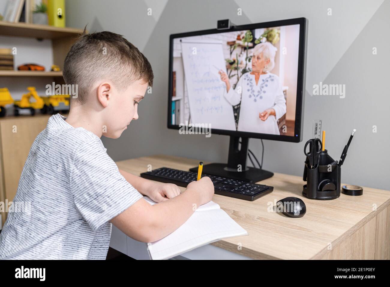 Schoolkid watching online video classes on the PC Stock Photo - Alamy