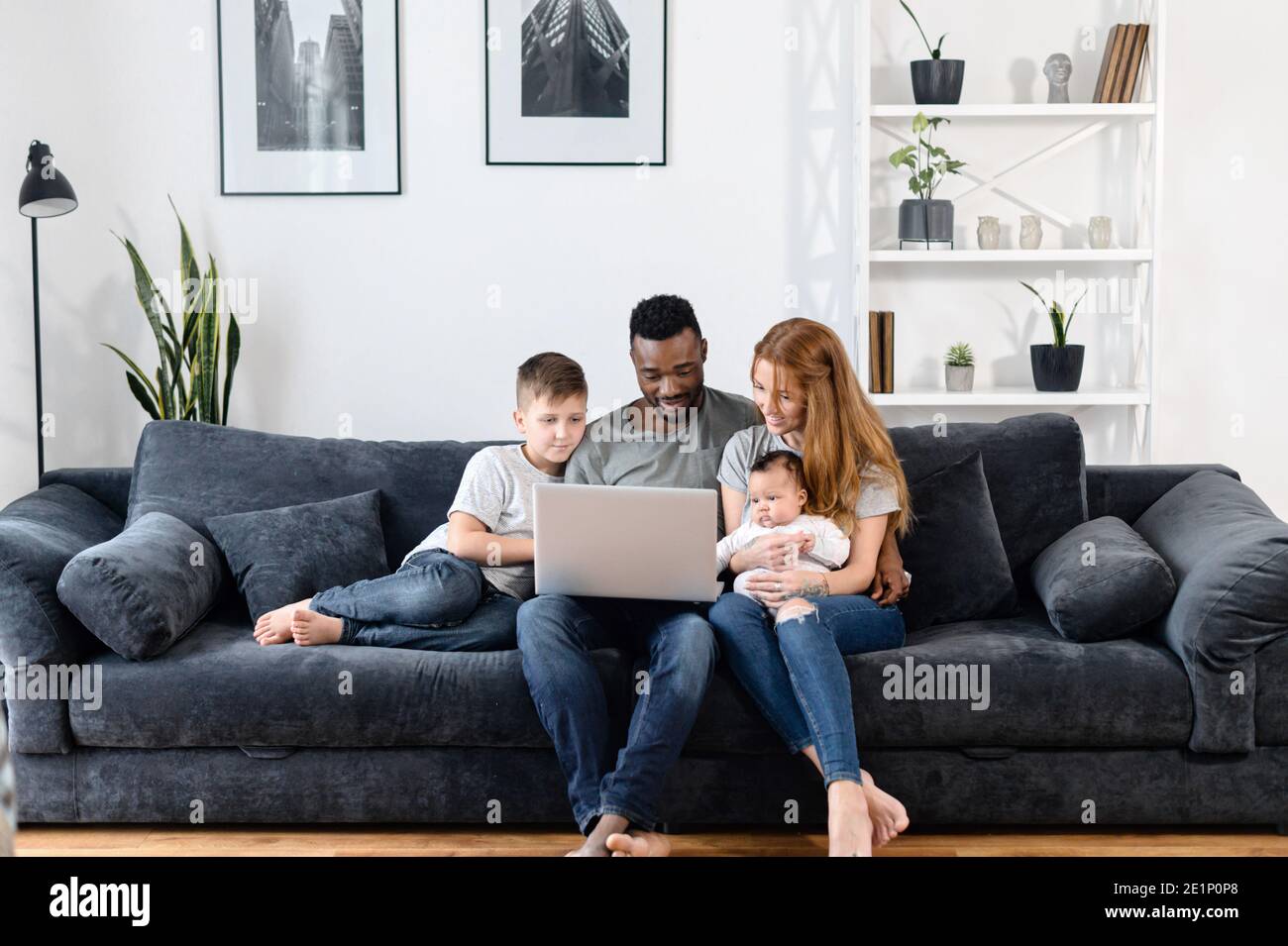 A multiracial family on the couch at home Stock Photo - Alamy