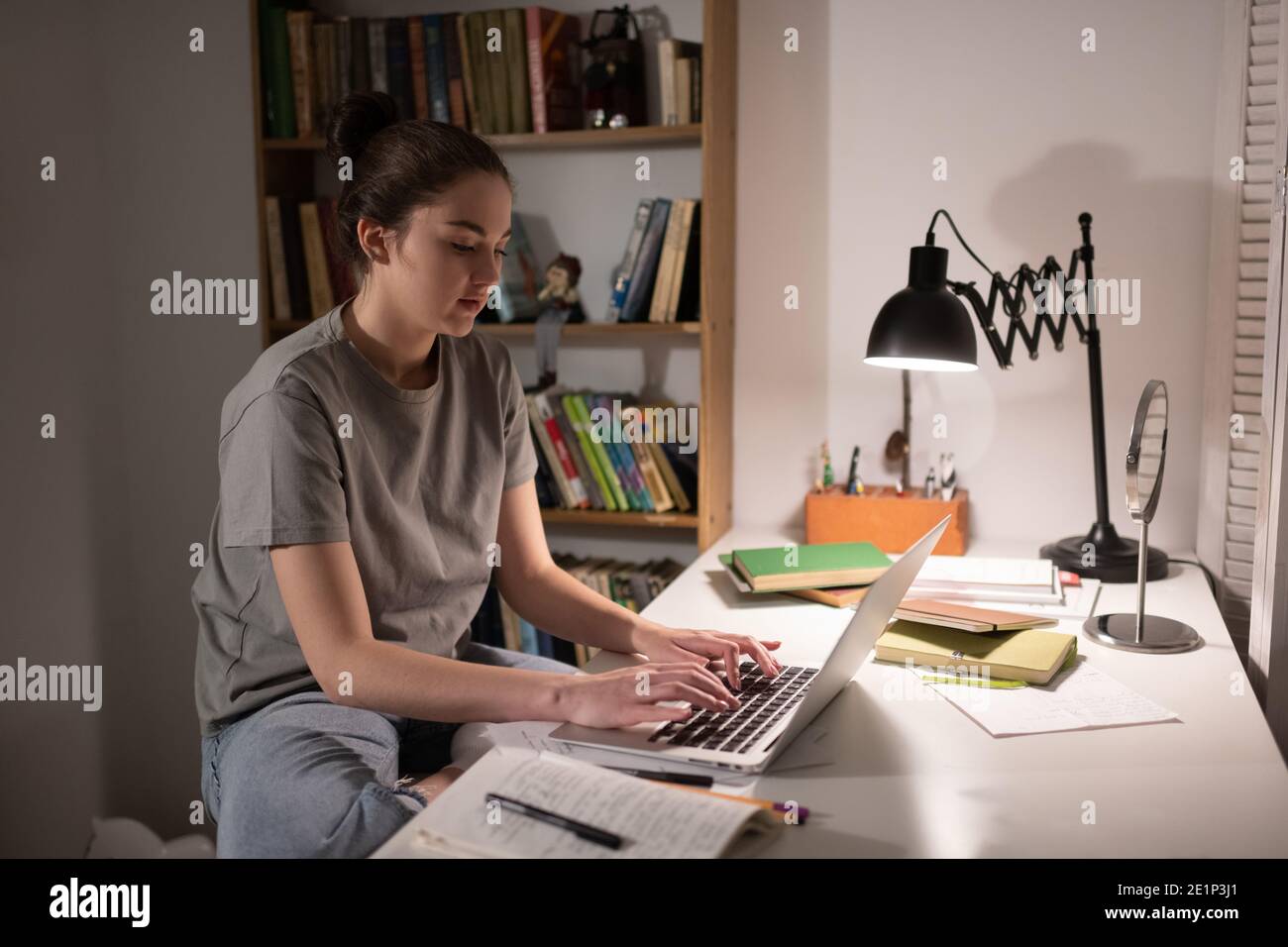 Smart female student typing on netbook during distance learning from ...