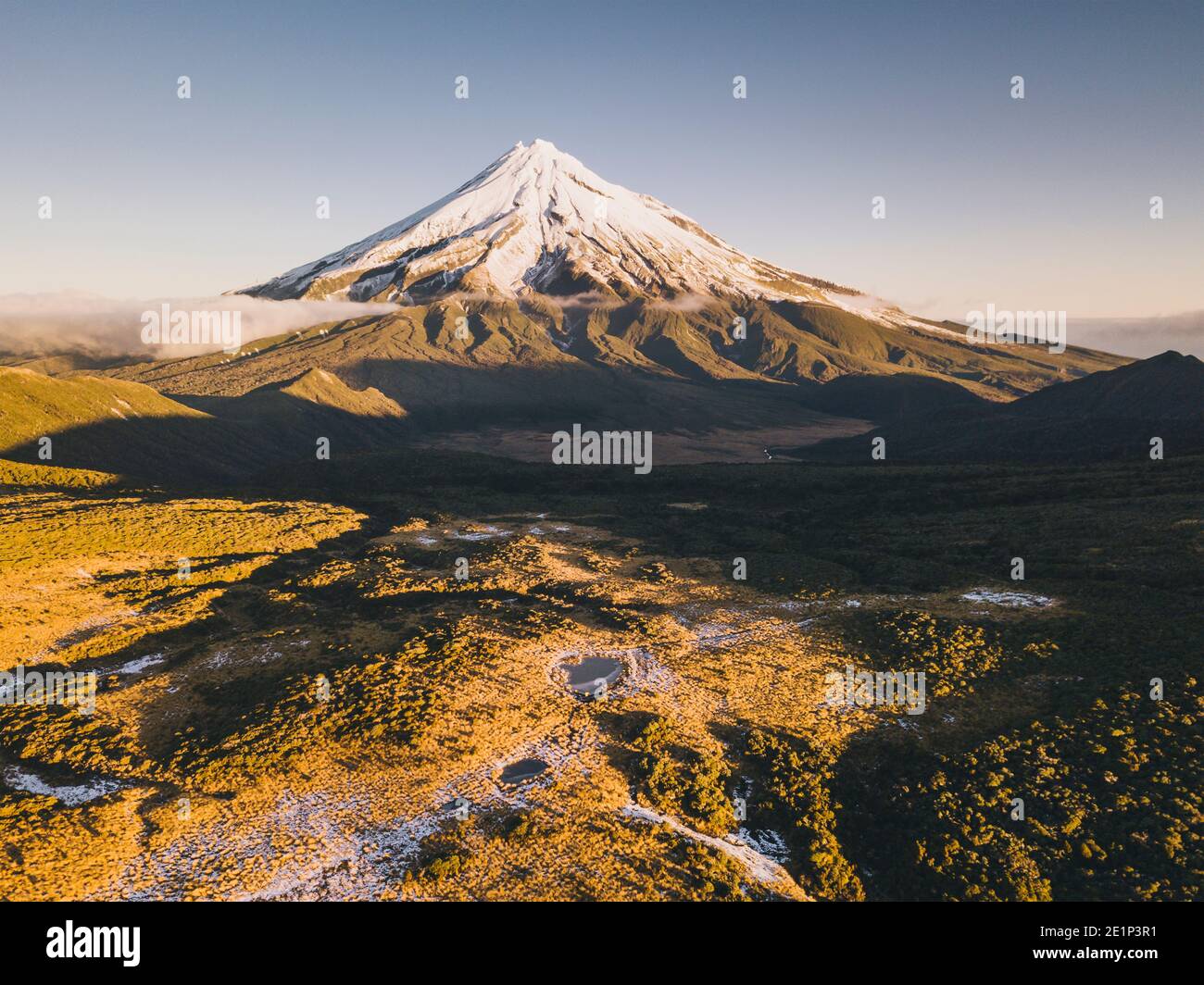 Mount Taranaki volcano after the first snowfall of the season at sunset ...