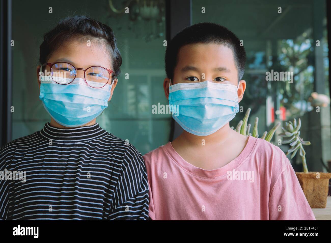 two asian children wearing protection face mask standing at home Stock ...