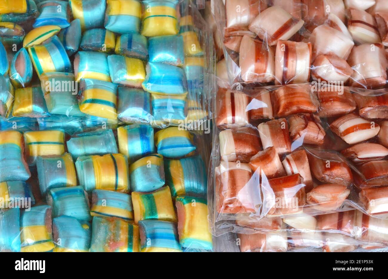 Multicolored candies in an transparent plastic wrap as a background ...