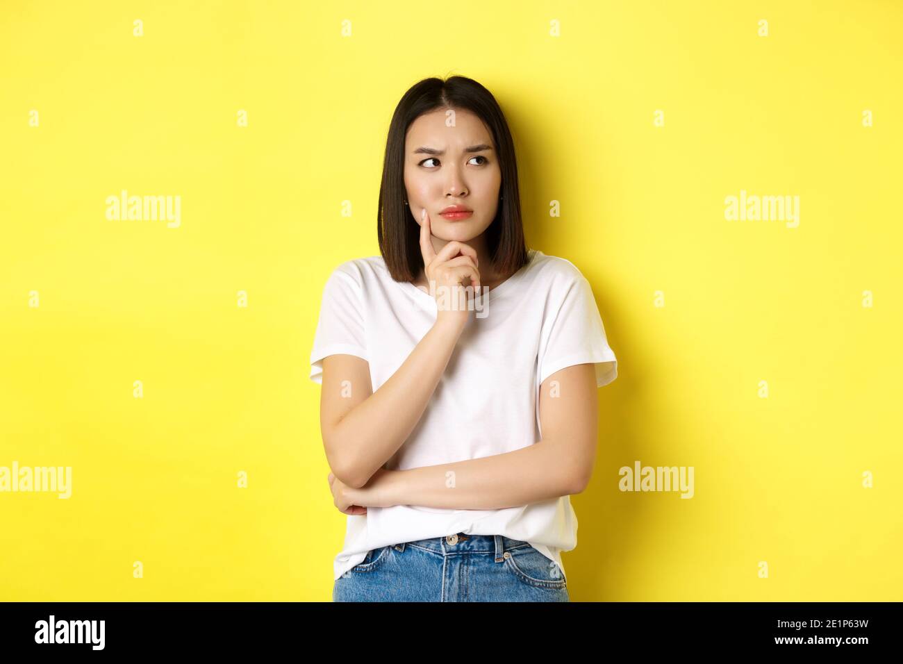 Beauty and fashion concept. Pensive asian woman thinking, looking ...