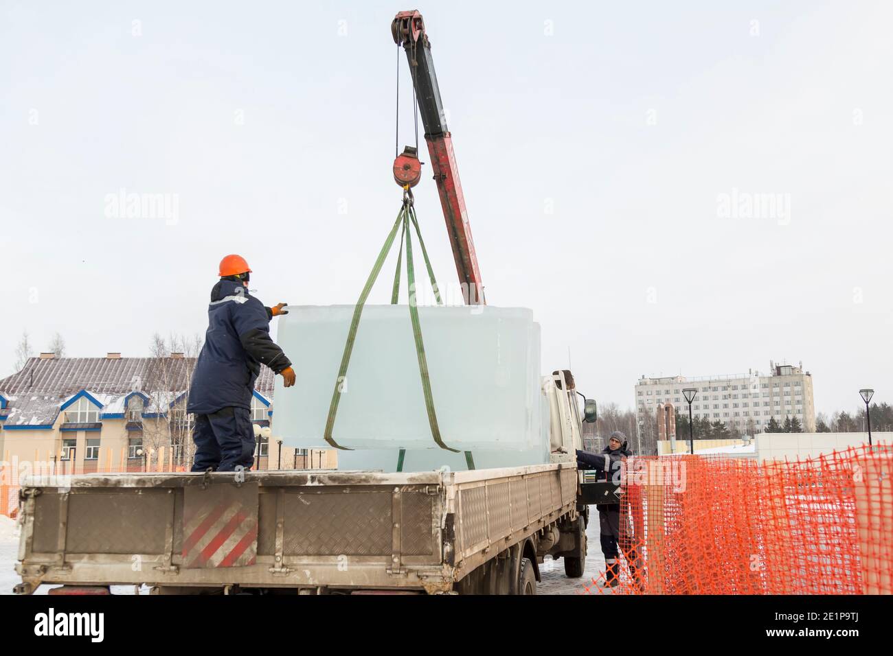 Assemblers unload ice panels from a car using a crane Stock Photo - Alamy