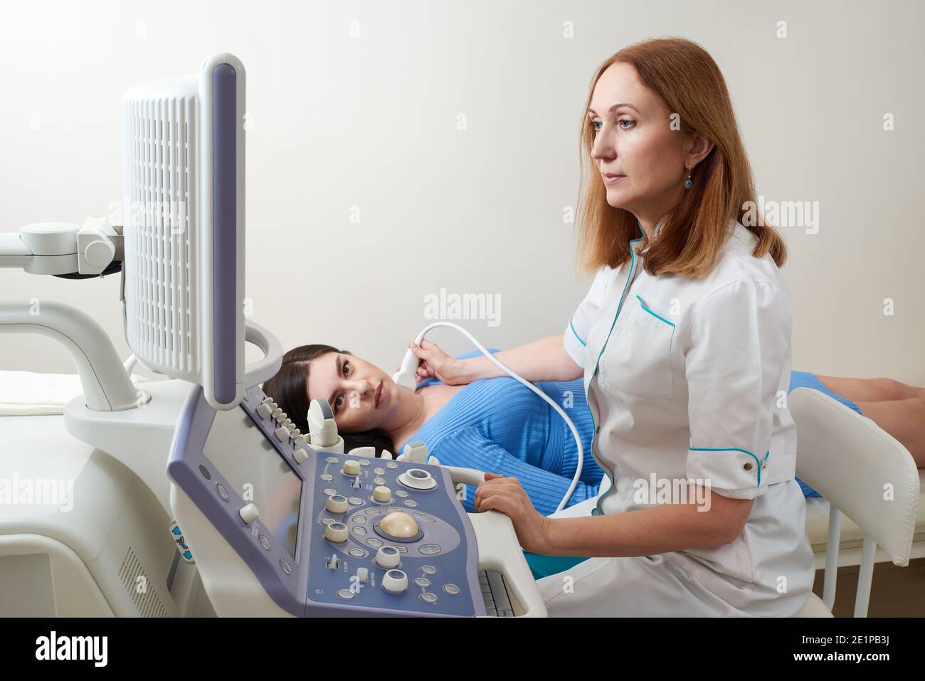 Doctor using ultrasound scanning machine examining female neck Stock ...