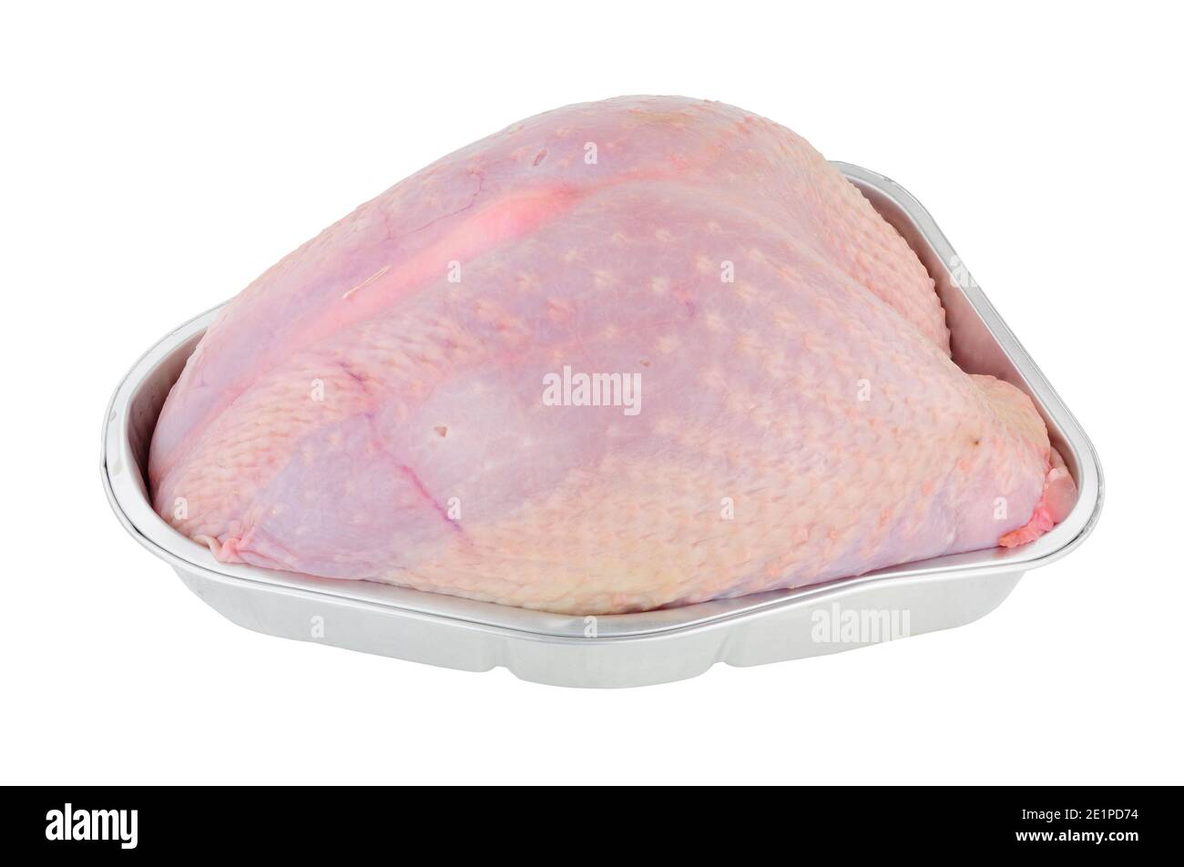 Whole raw turkey crown meat in a foil roasting tray isolated on a white ...
