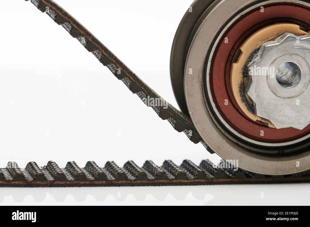 Toothed timing belt with roller close up view isolated on white ...