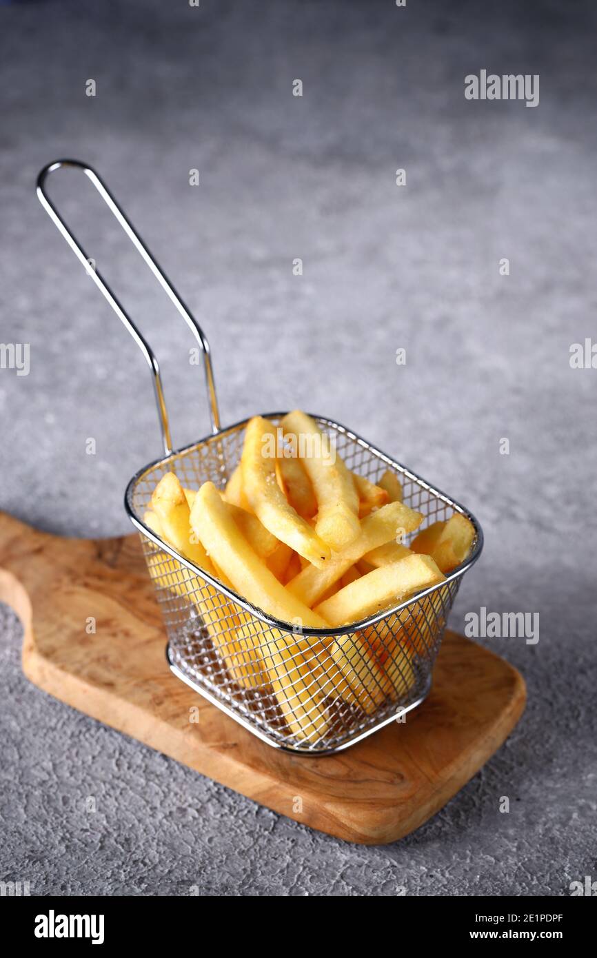 French fries in a metal basket mesh Stock Photo - Alamy