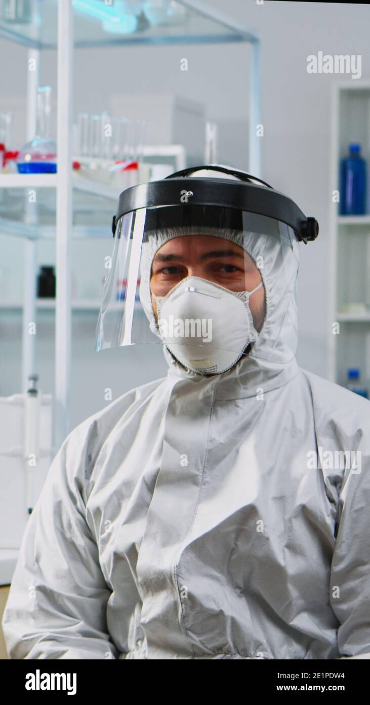 Close up of tired chemist man doctor in coverall working in scientific ...