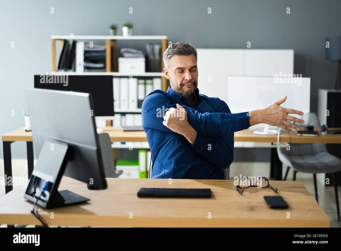 Stretch Exercise At Office Desk At Work. Stress Break Stock Photo - Alamy