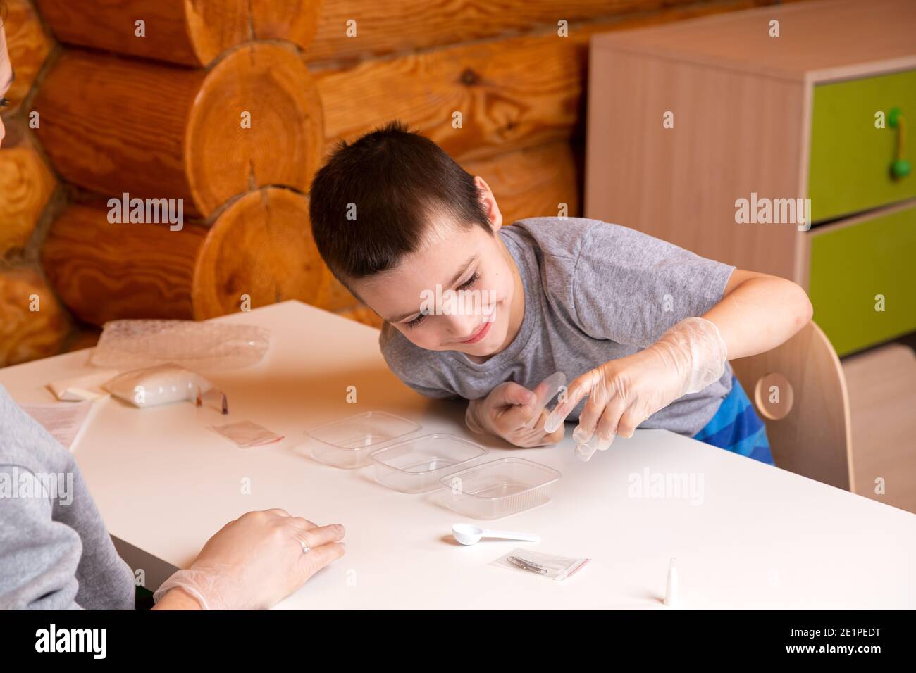 a little boy and his mother arrange containers for various chemical ...