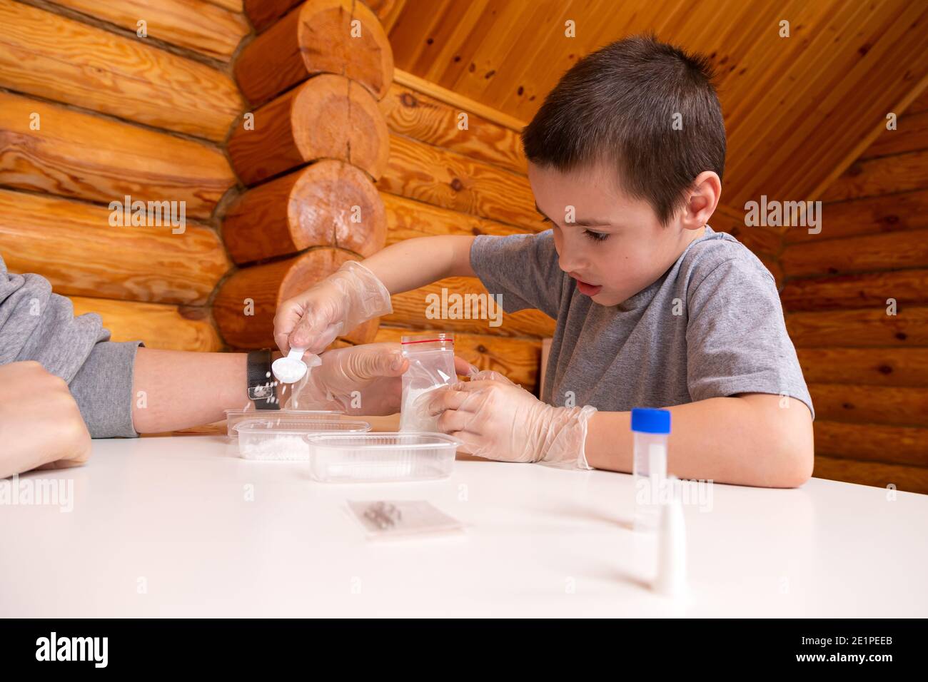 Chemistry education and study concept. Mom and her son stirs measuring ...