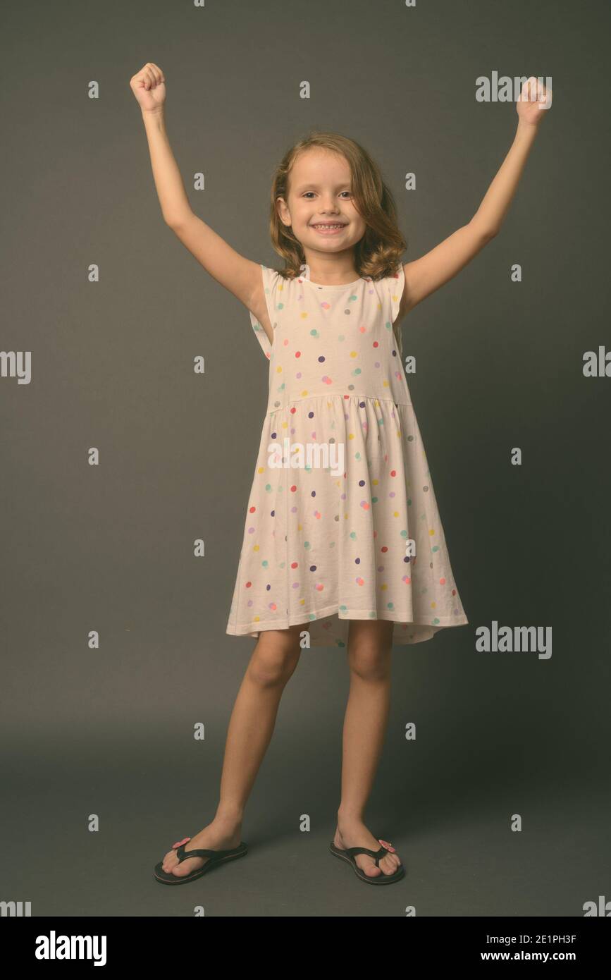 Cute young girl with blond hair against gray background Stock Photo - Alamy