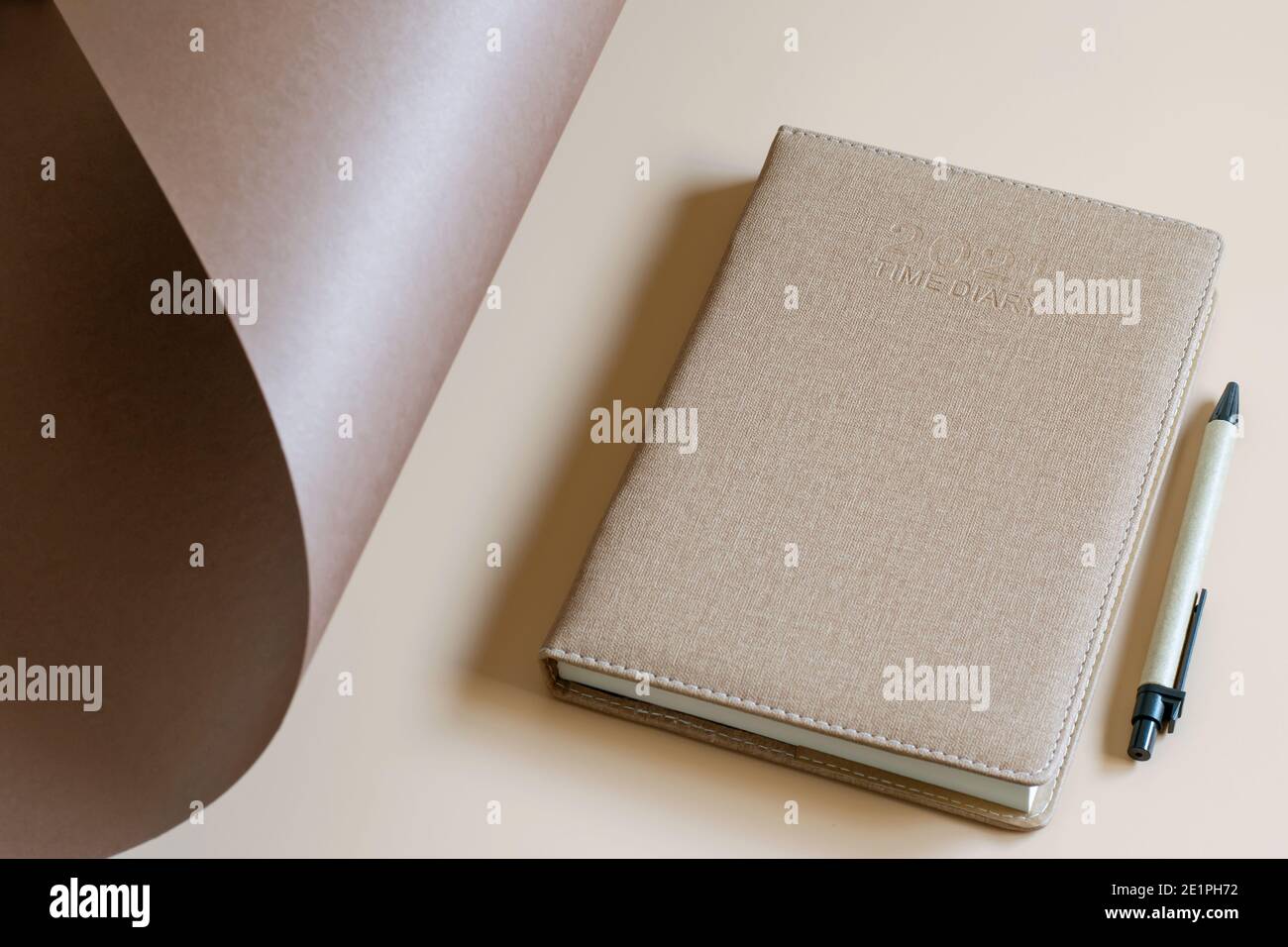 New textured time diary, pen and sheet of paper on the beige background ...