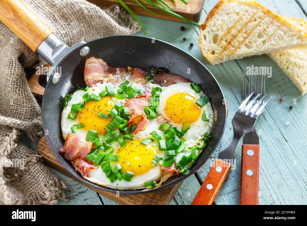 Spring scrambled eggs with green onions and bacon in a cast iron ...