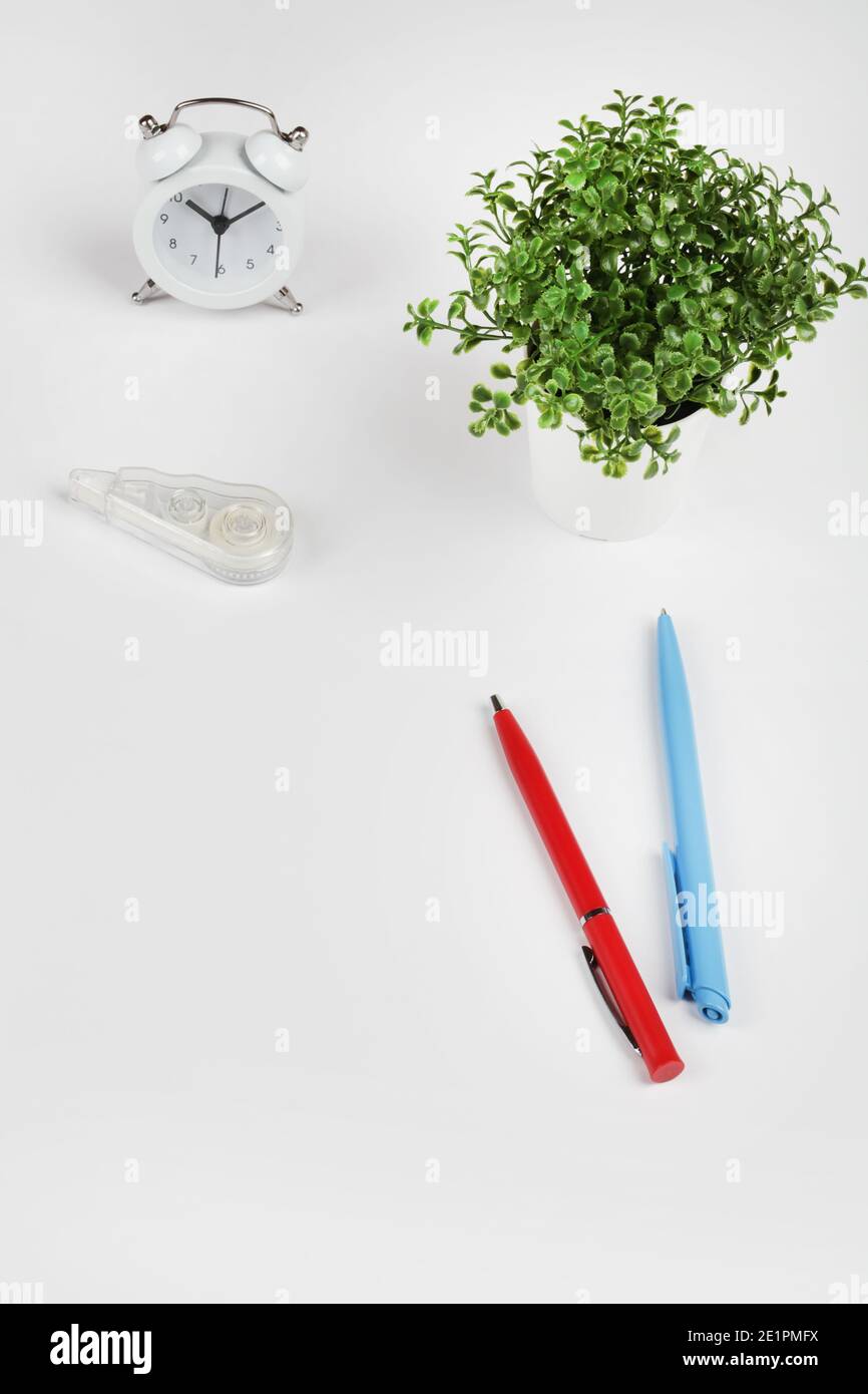 Working table with flower, clock, eraser and two pens. Top view. flat ...