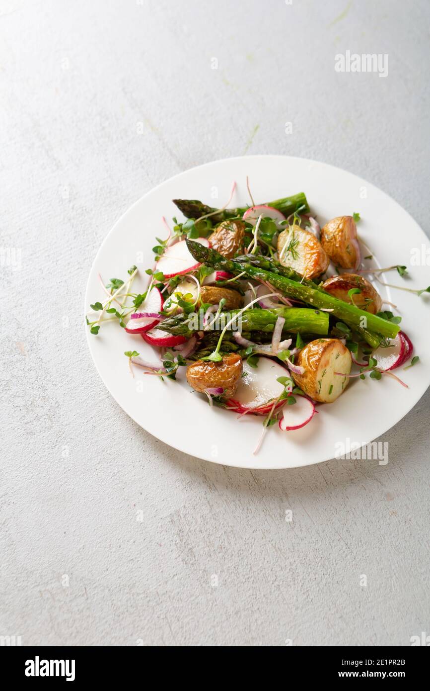 Roasted asparagus and potato spring salad on white plate Stock Photo ...