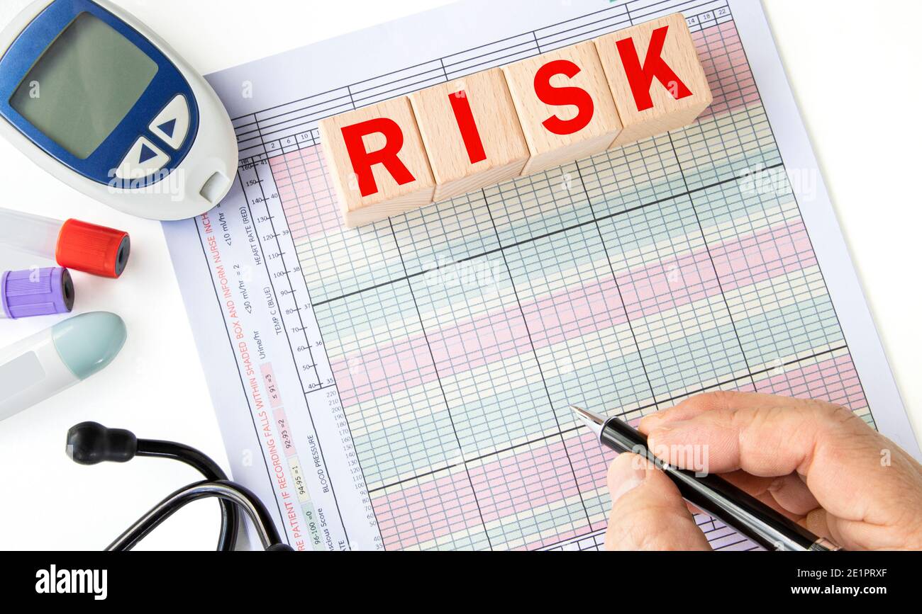A doctor writing record on a patient vital signs sheet with wood blocks ...