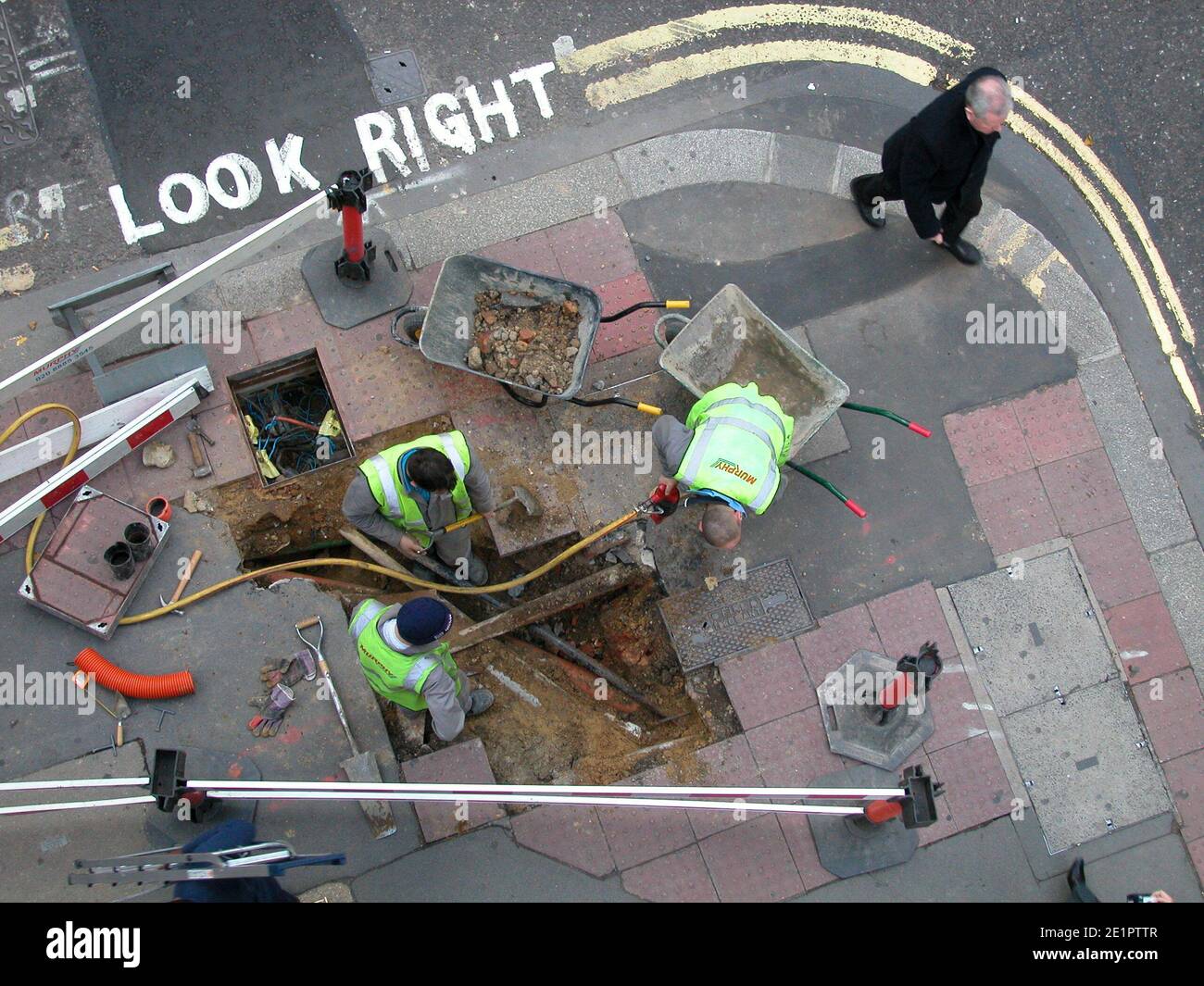 Laying cables under paving Murphy Cable layers Workmen digging up road ...