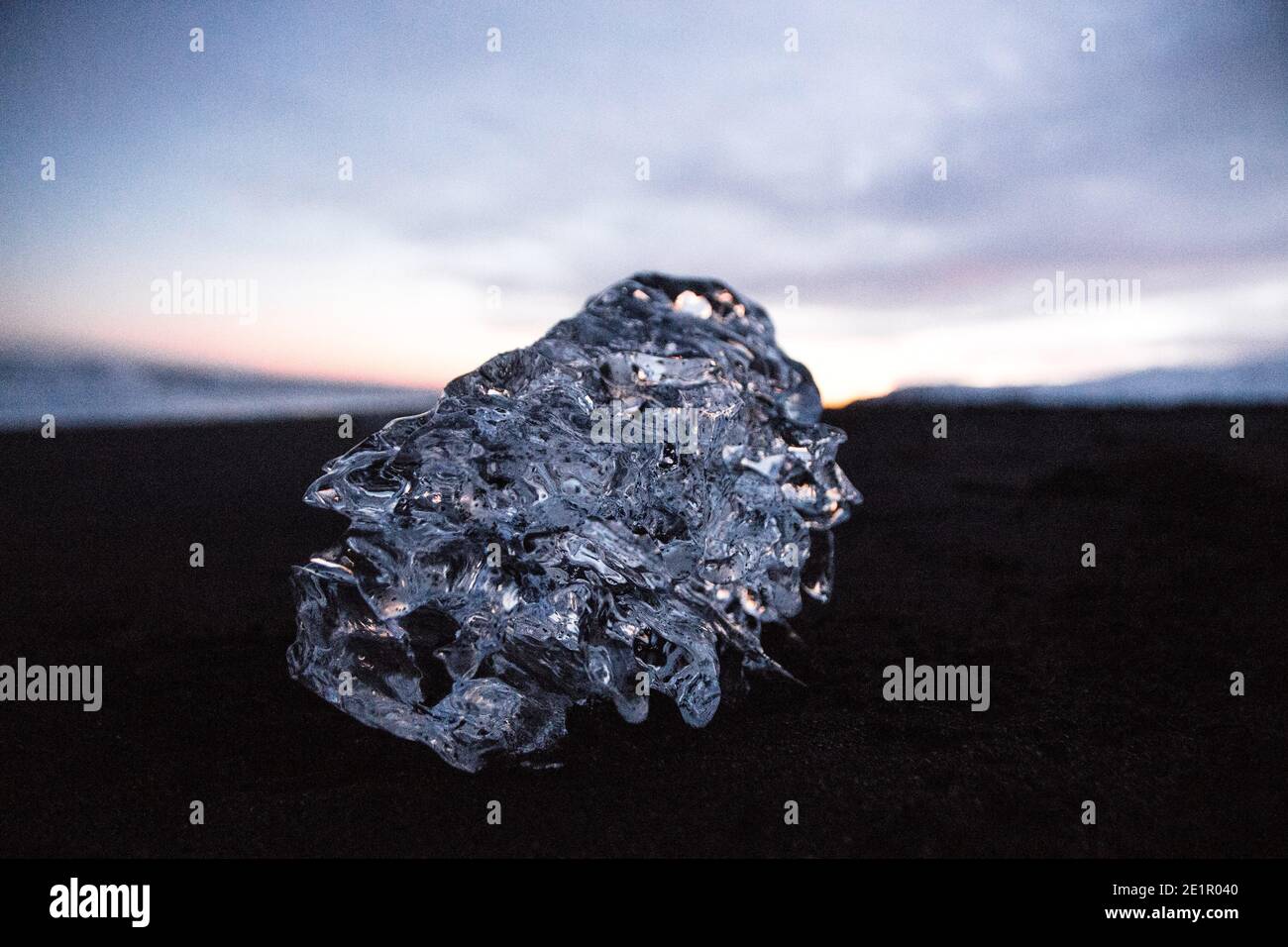 Ice crystal part piece iceberg block glacial fragment on black sand ...