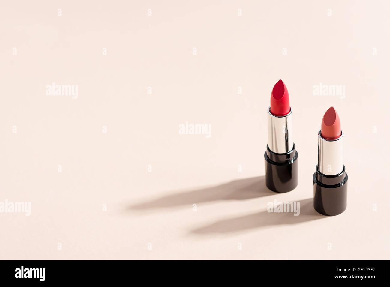 Two red lipsticks on beige background with copy space. Fashion blog ...