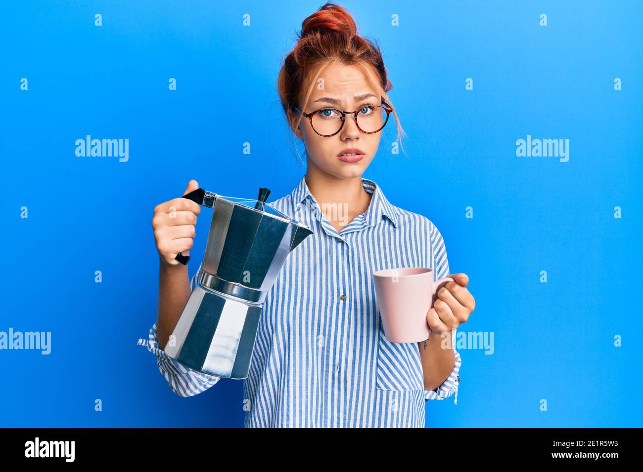Young redhead woman drinking italian coffee skeptic and nervous ...
