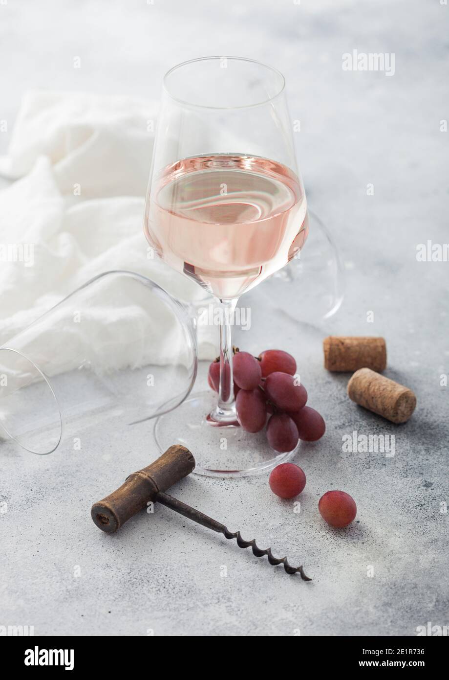 Glass of pink rose homemade wine with corks, corkscrew and grapes on ...