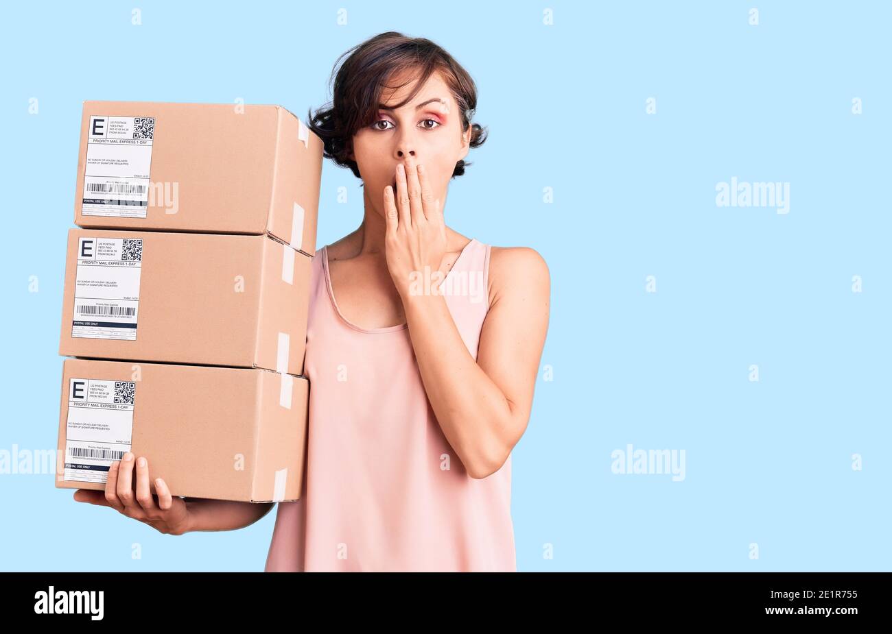 Beautiful young woman with short hair holding delivery packages ...
