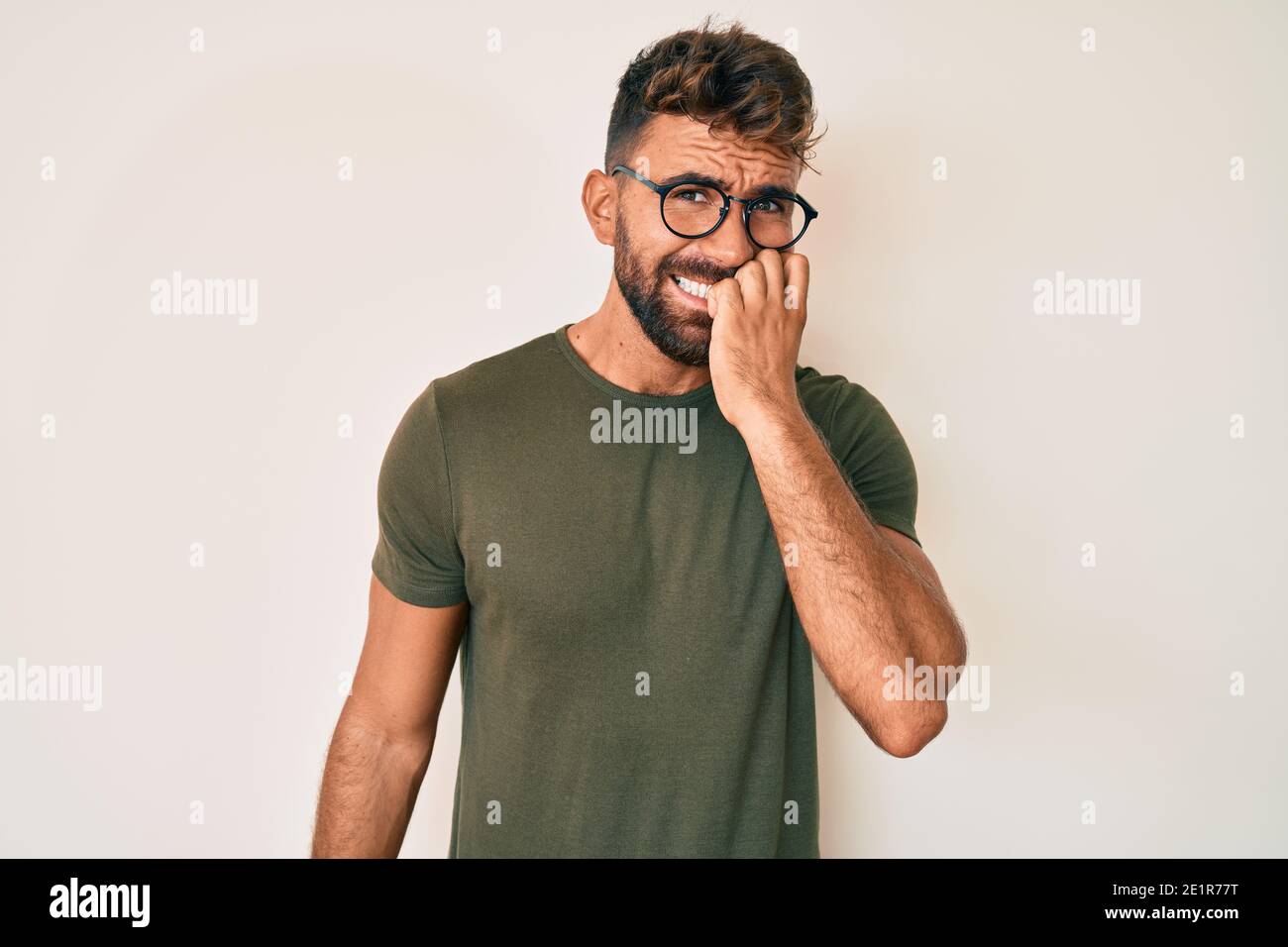 Young hispanic man wearing casual clothes and glasses looking stressed ...