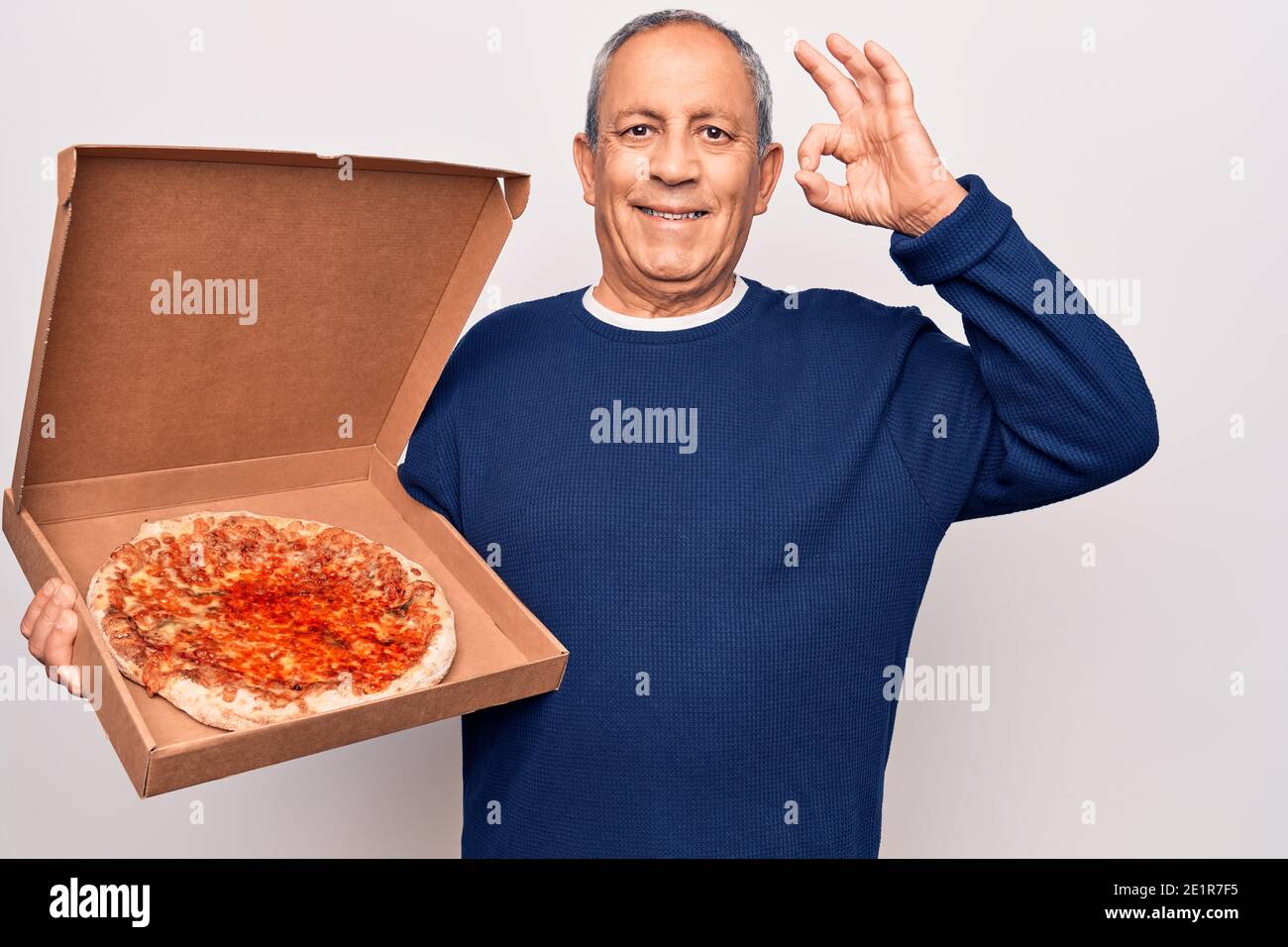 Senior man with grey hair holding delivery box of italian pizza doing ...