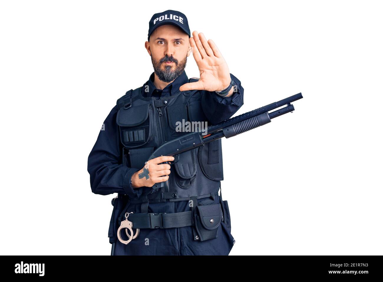 Young handsome man wearing police uniform holding shotgun with open ...