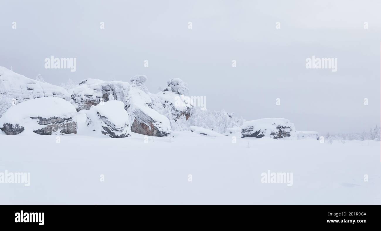 winter landscape - snow-capped granite rocks in the middle of white ...